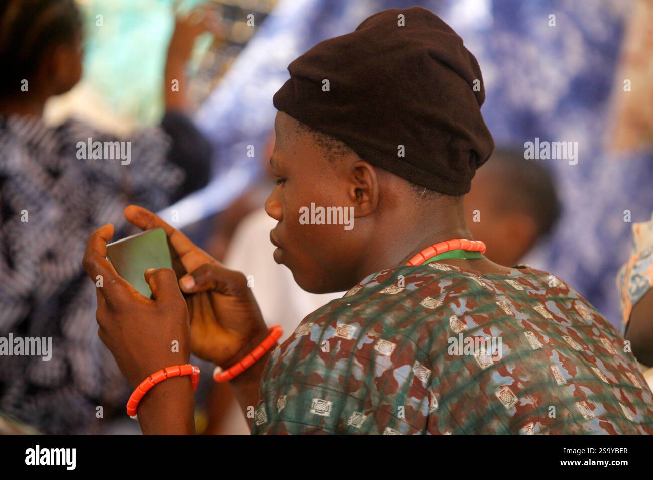 A member of a cultural group dressed in Adire sits during the grand finale of the 2025 edition ...
