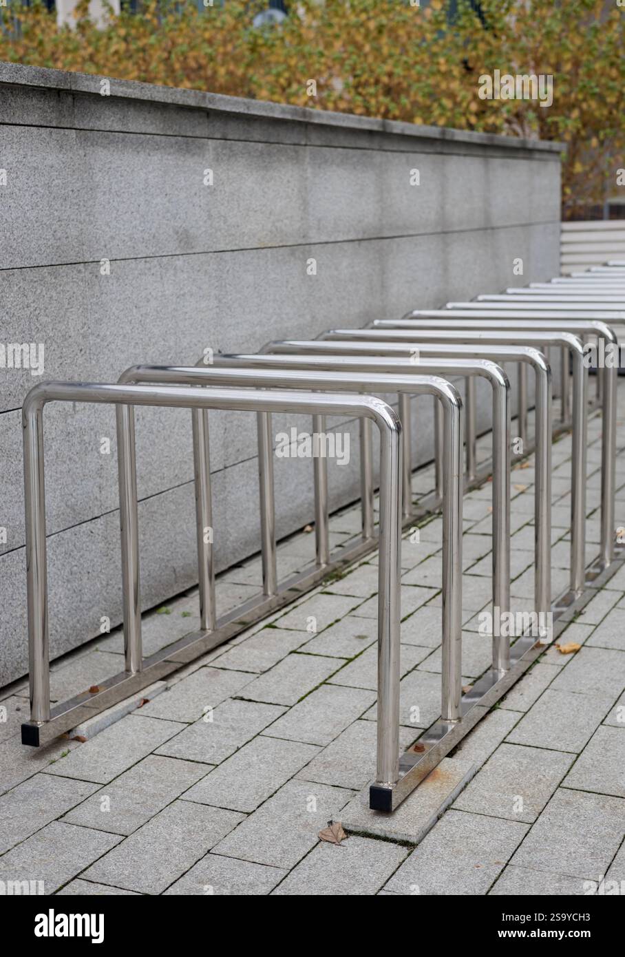 Linear arrangement of polished steel bicycle racks with urban ...