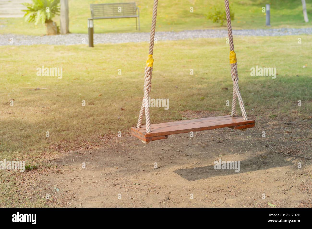 wooden swing on rope in backyard garden with copy space. Recreation in ...