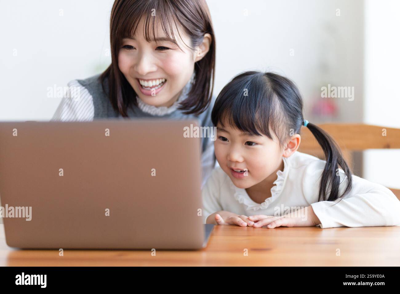 Parents and children looking at a computer Stock Photo - Alamy
