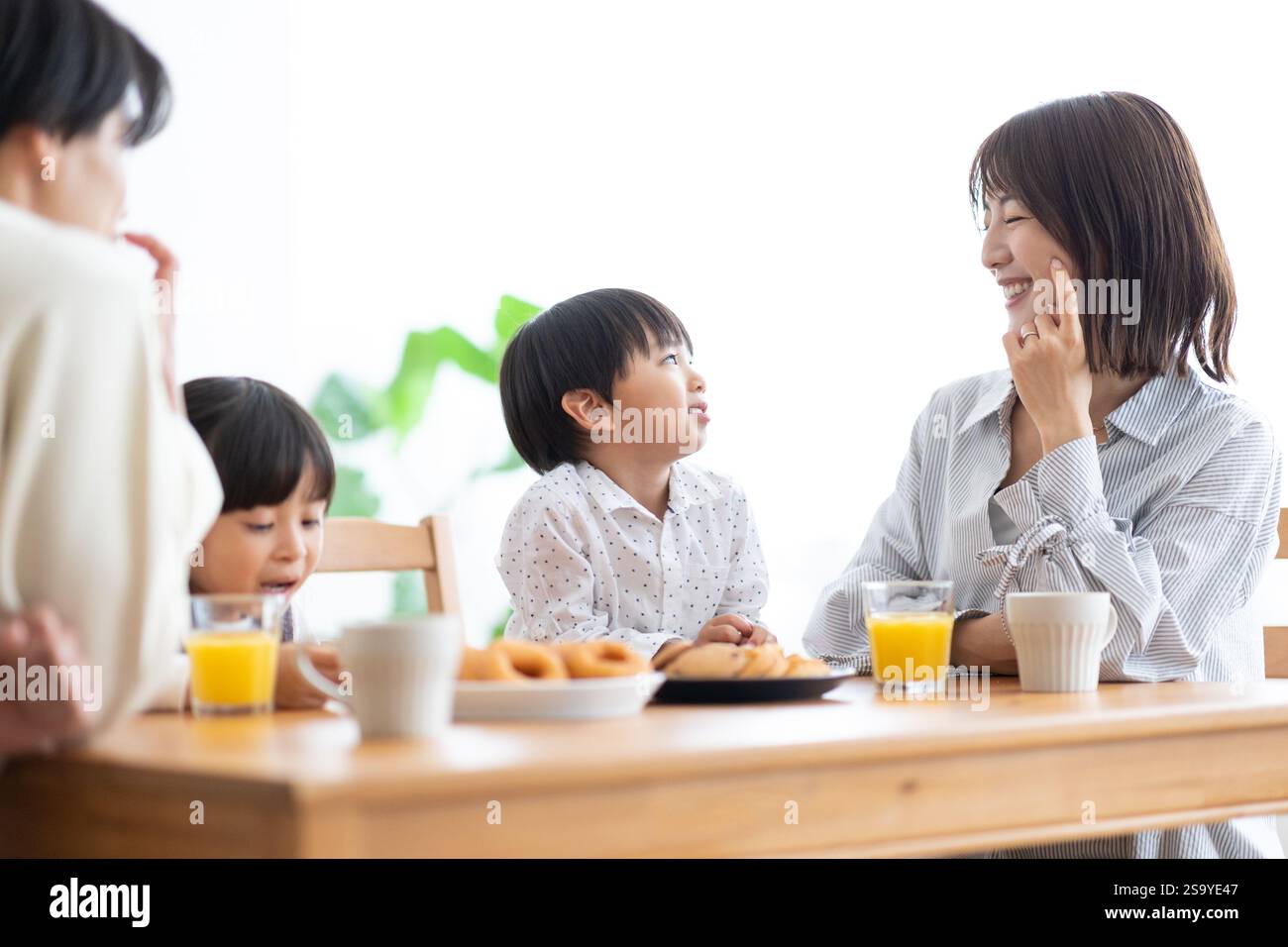 Family around table Stock Photo - Alamy