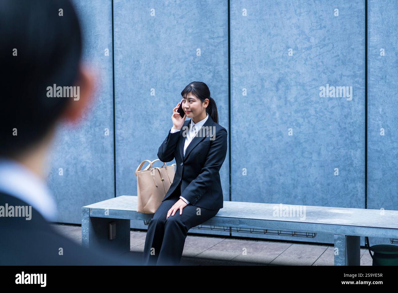 Newly graduated woman sitting on bench Stock Photo - Alamy