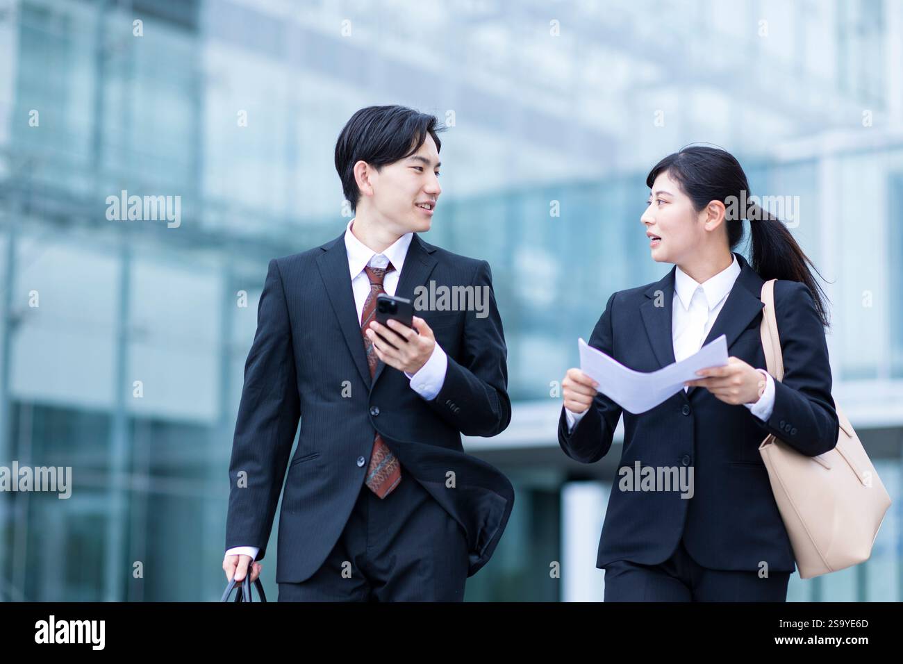 Man and woman walking while talking Stock Photo - Alamy