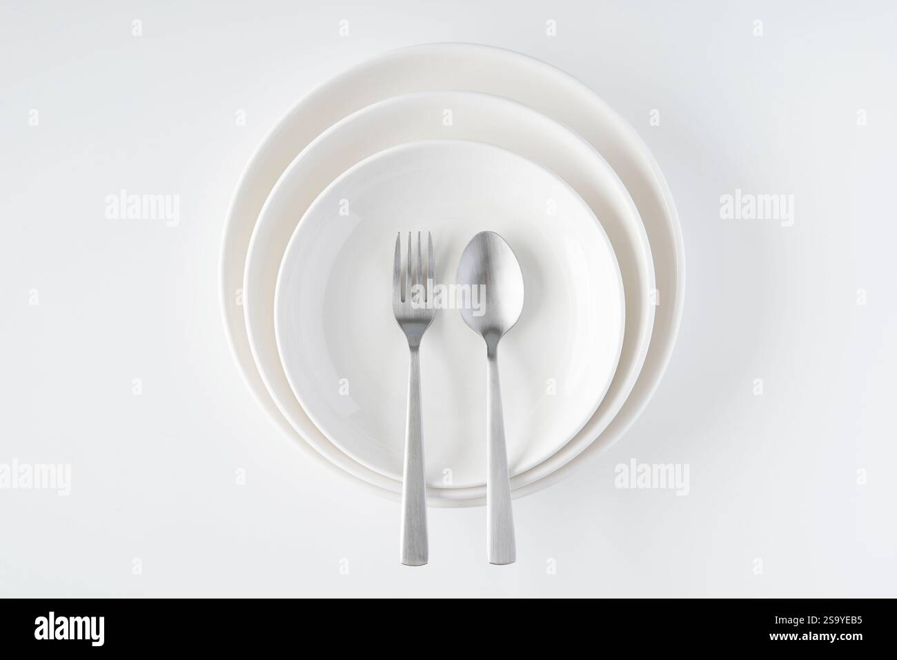Stacked white plates, forks and spoons Stock Photo - Alamy