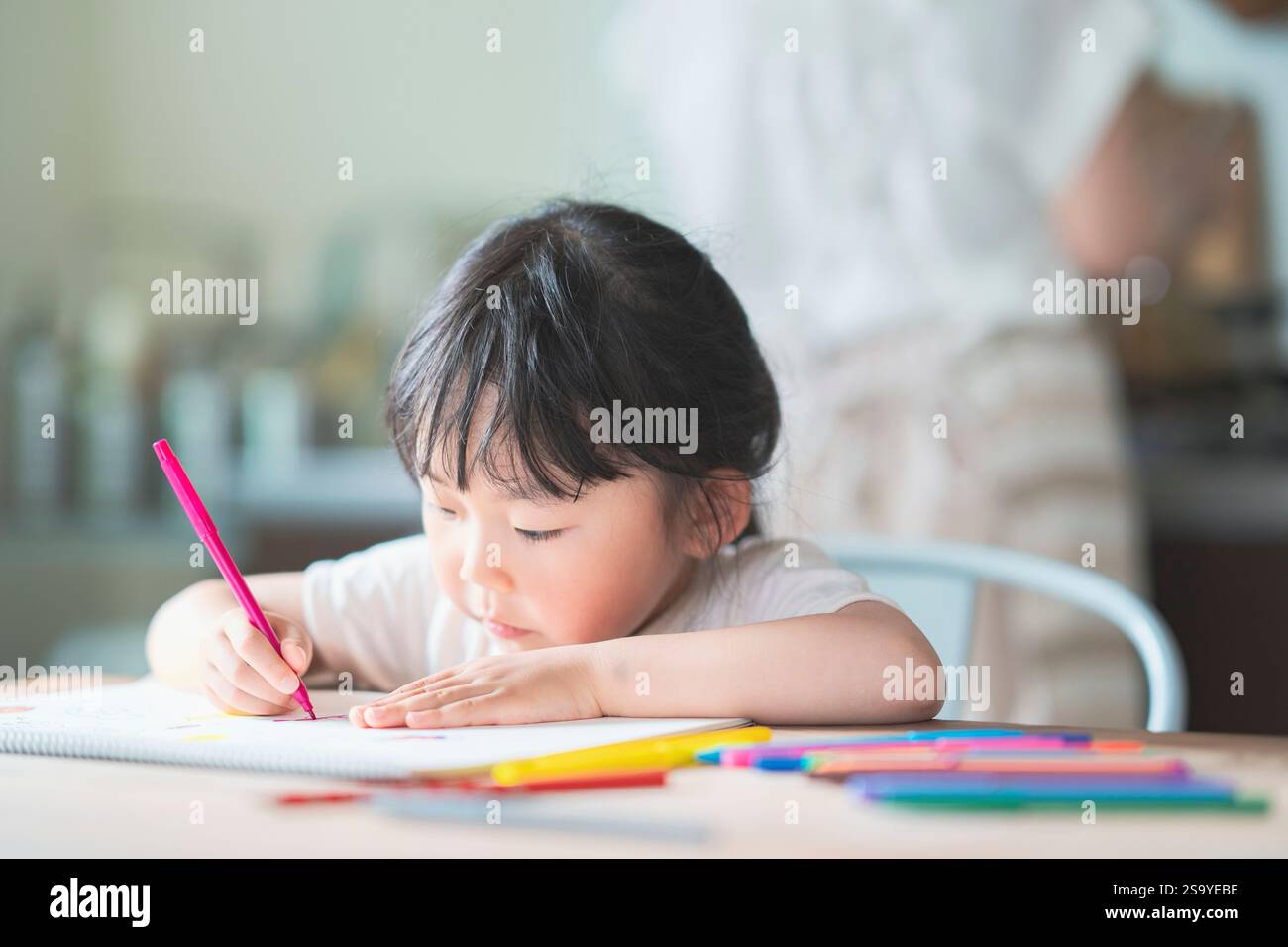 Child drawing at dining table Stock Photo - Alamy