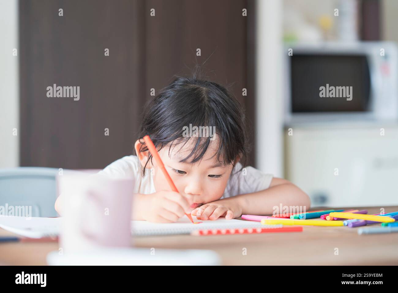 Child drawing at dining table Stock Photo - Alamy
