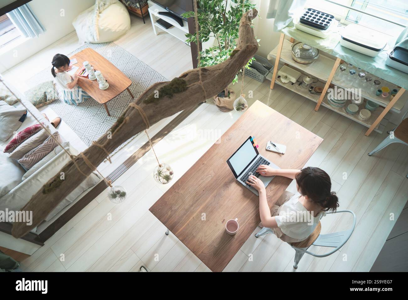 Telework image Woman working in living room and child playing Stock ...