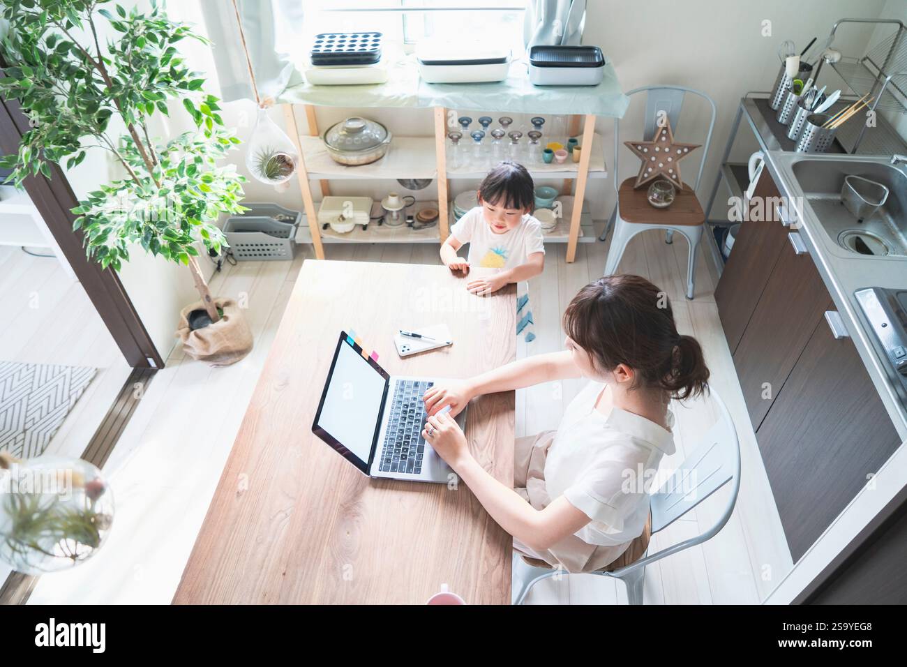 Telework image Woman working in living room and child playing Stock ...