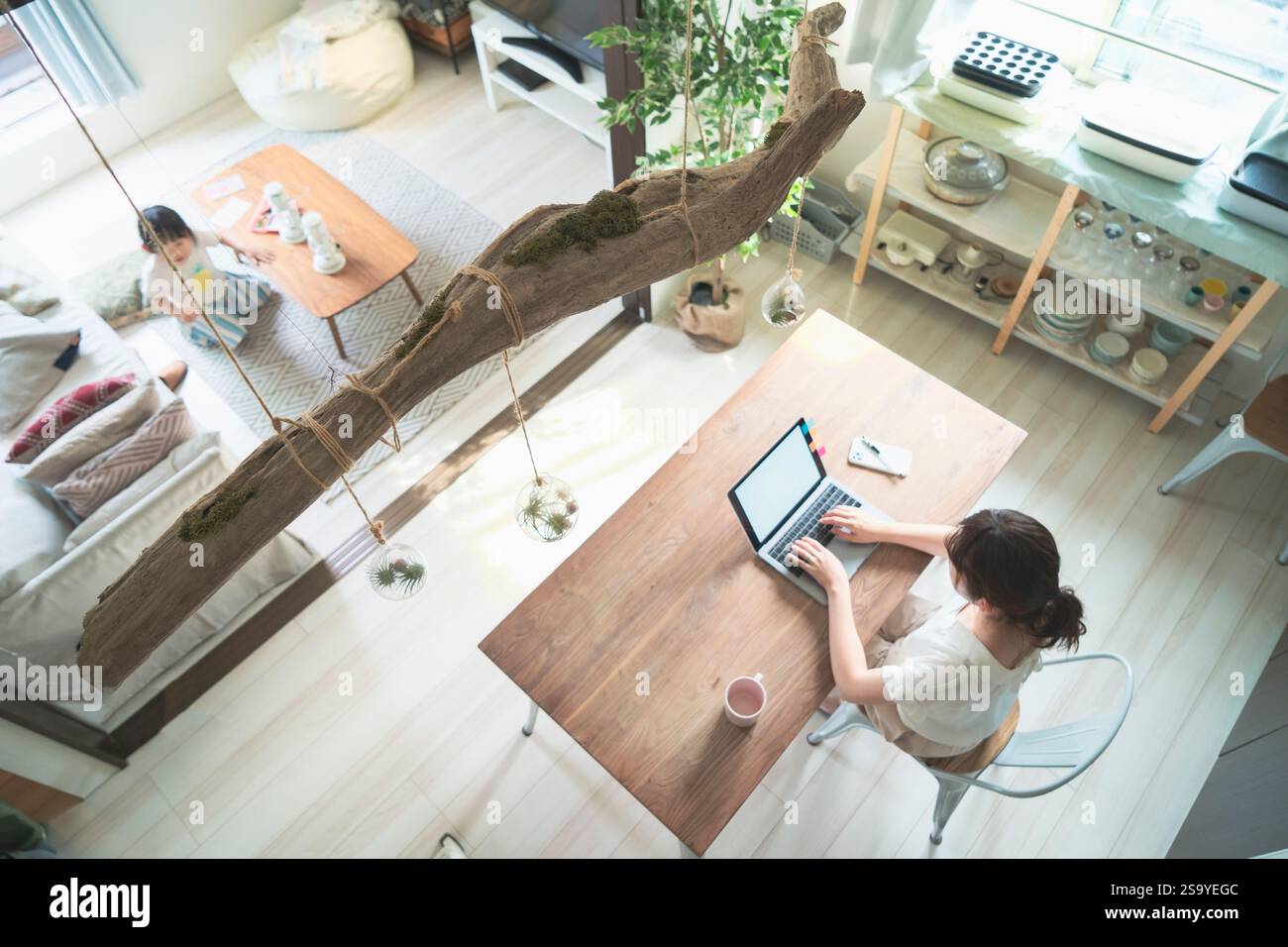 Telework image Woman working in living room and child playing Stock ...