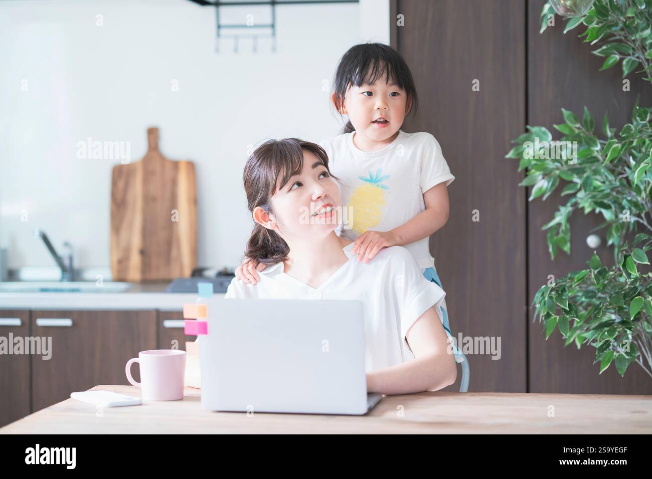 Telework image Woman working in living room and child playing Stock ...