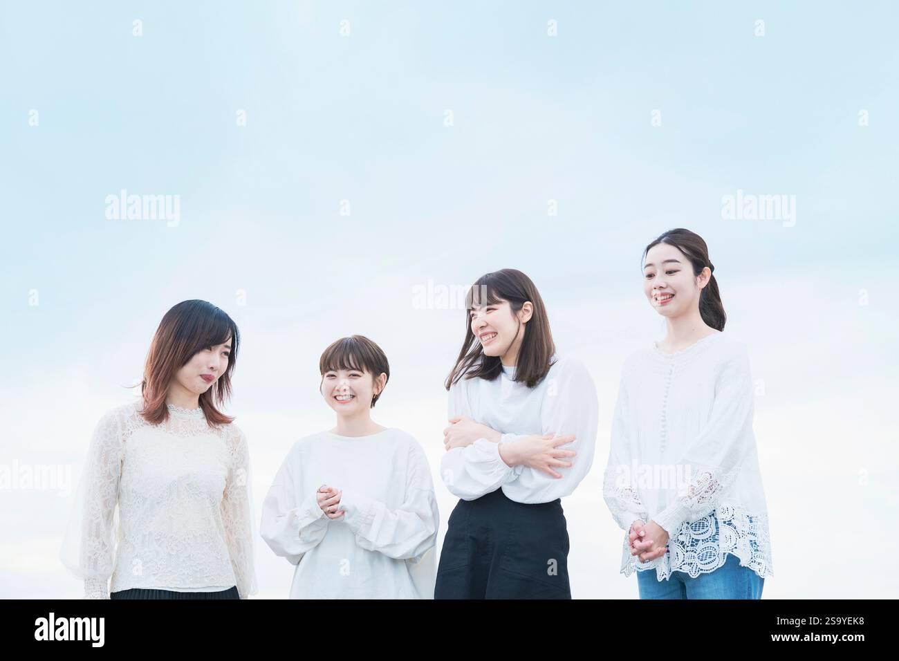 Four women smiling and talking Stock Photo - Alamy