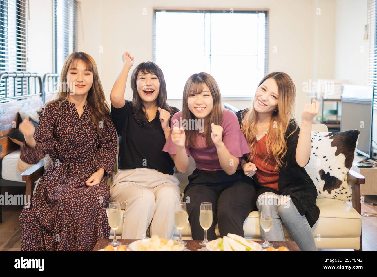 Four women watching a sports match indoors Stock Photo - Alamy