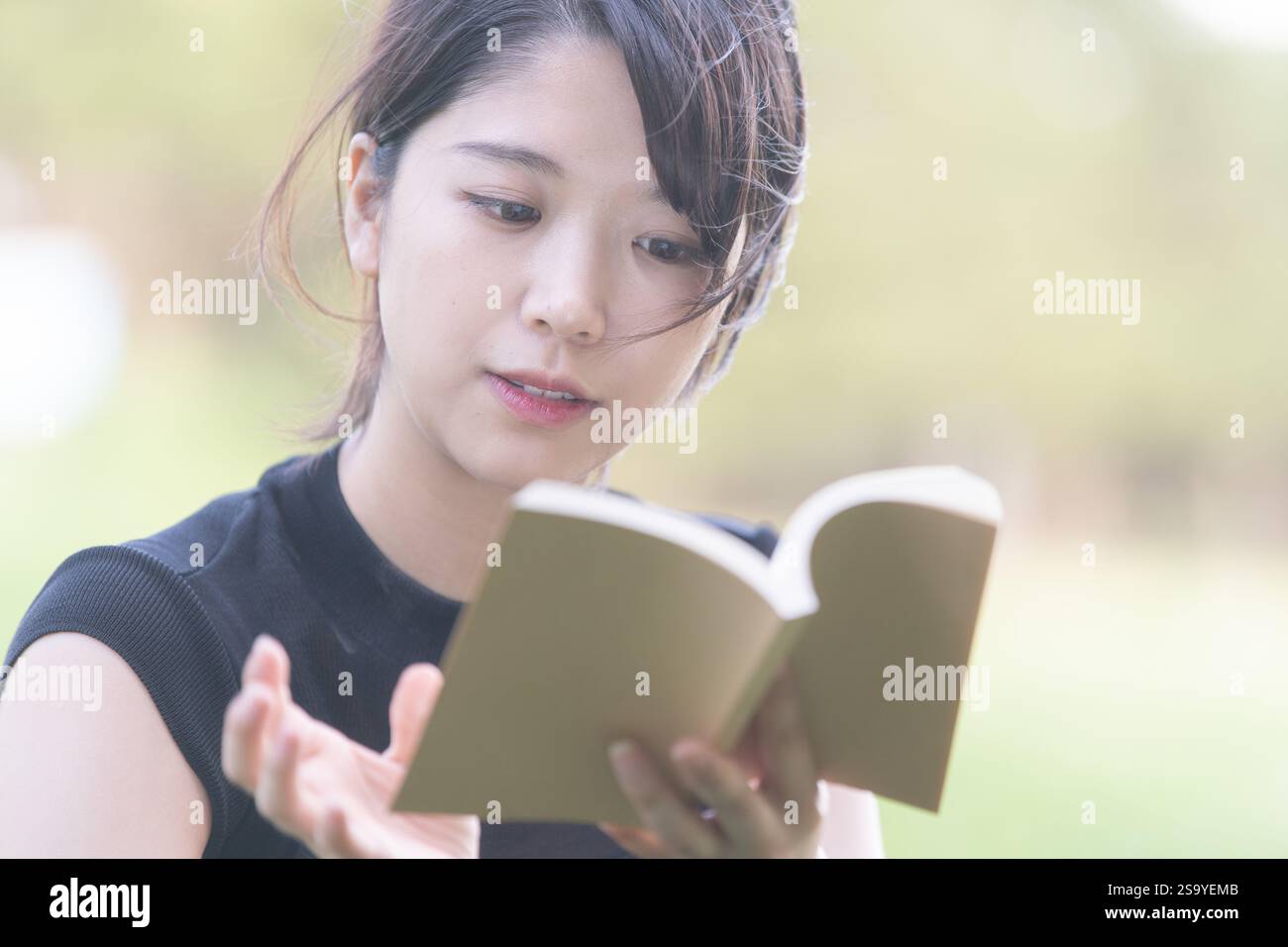 Female university student reading a book Stock Photo - Alamy