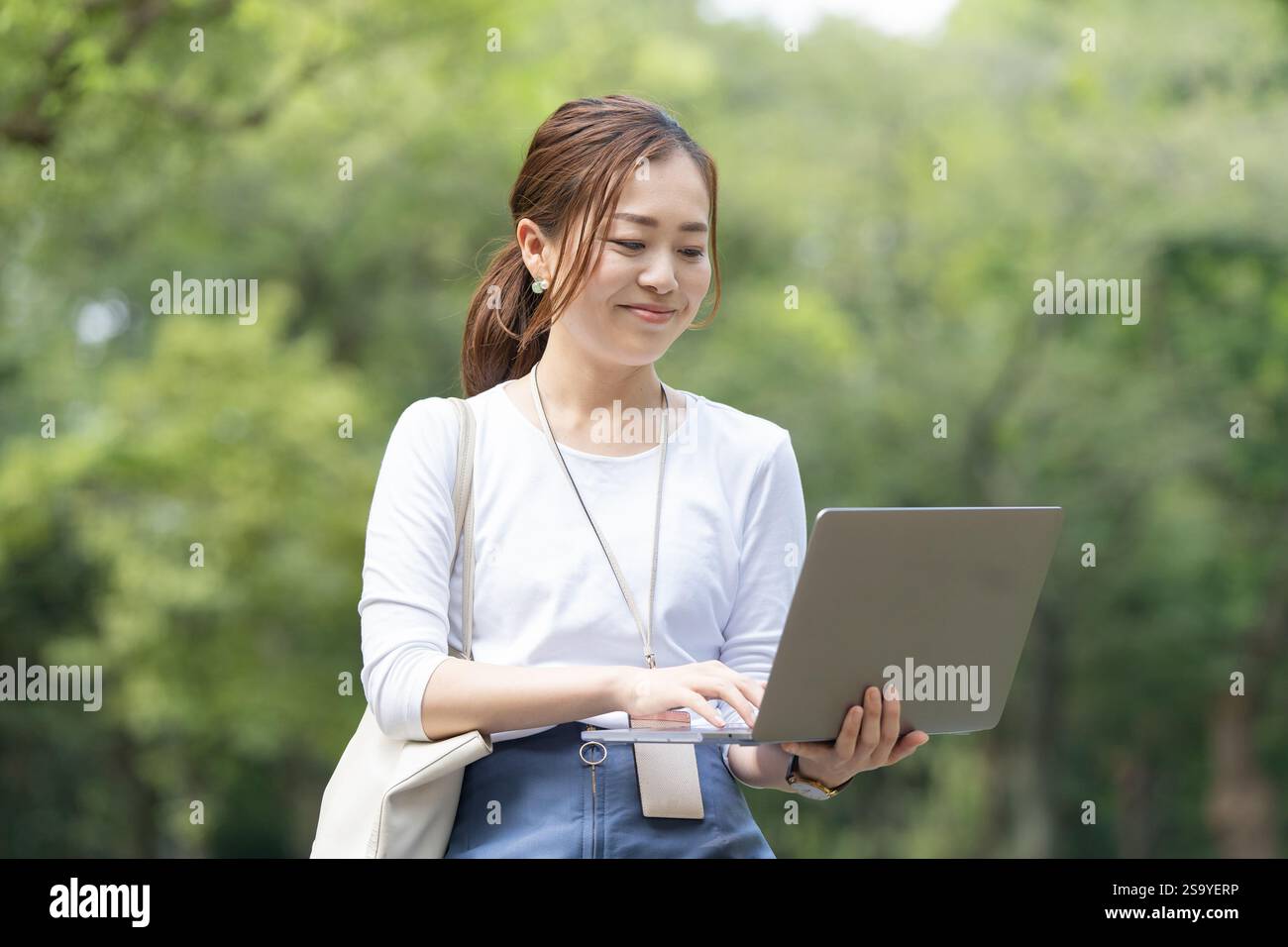 Woman operating a laptop outdoors Stock Photo - Alamy
