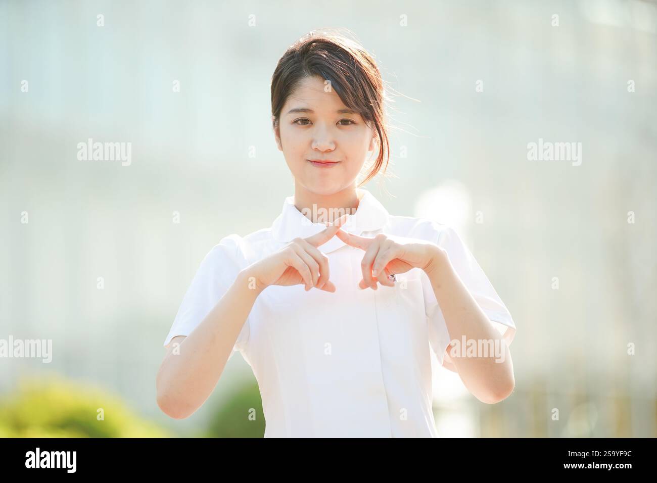 Woman in white making the ‘Butu’ sign Stock Photo - Alamy