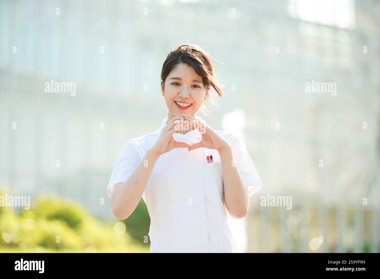Woman in white making the ‘Maru’ sign Stock Photo - Alamy