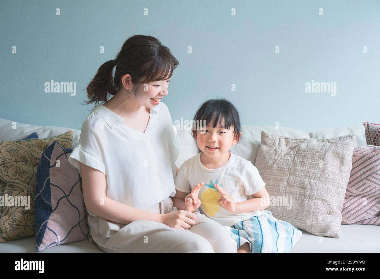 Parent and child sitting on the sofa and having a conversation Stock ...