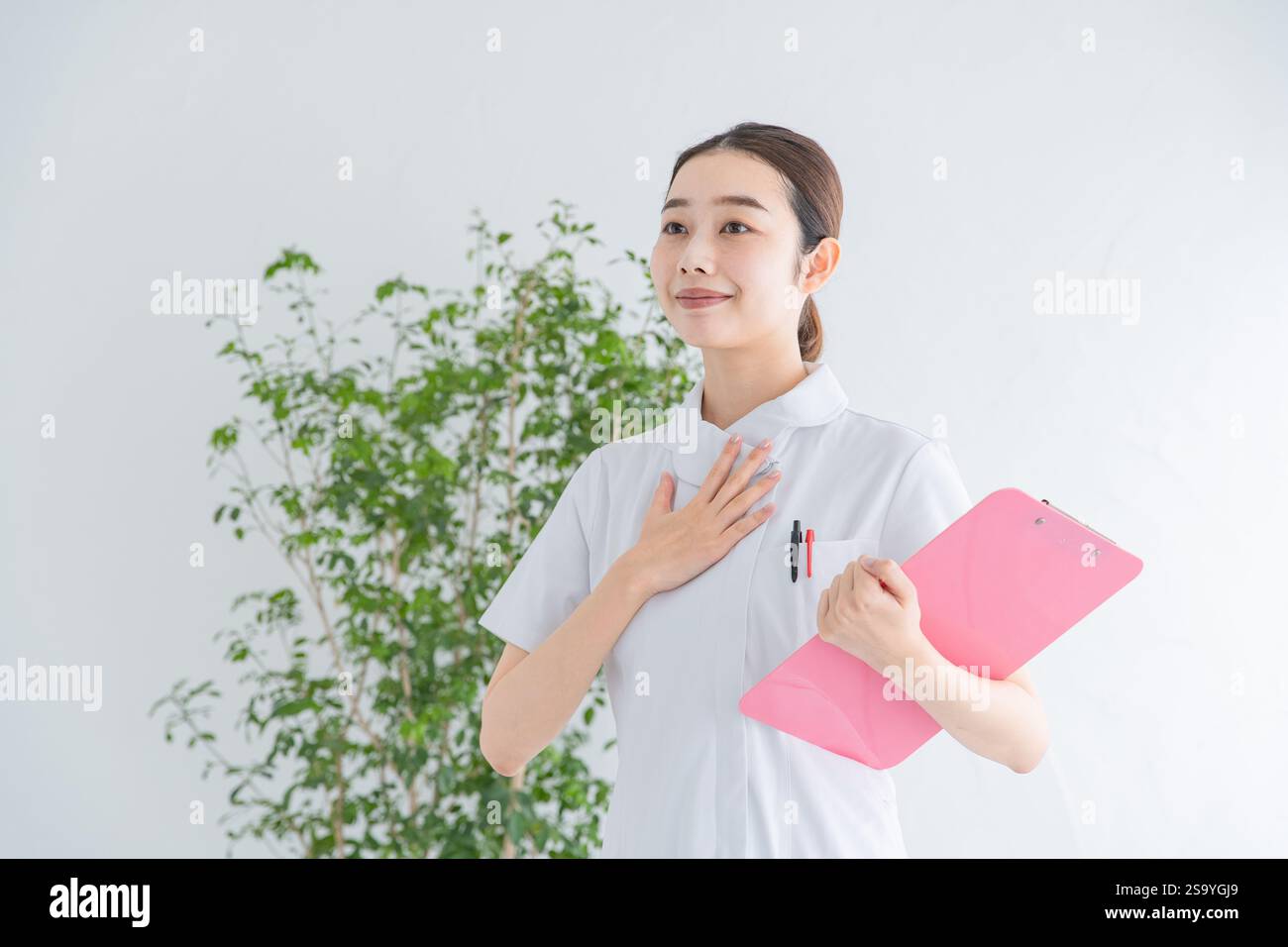 Woman in white patting down her chest Stock Photo - Alamy