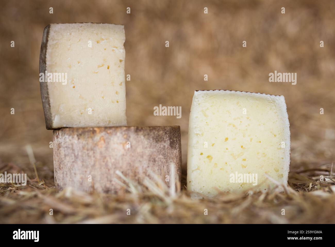 Whole head of ripe country cheese and slices on hay Stock Photo - Alamy