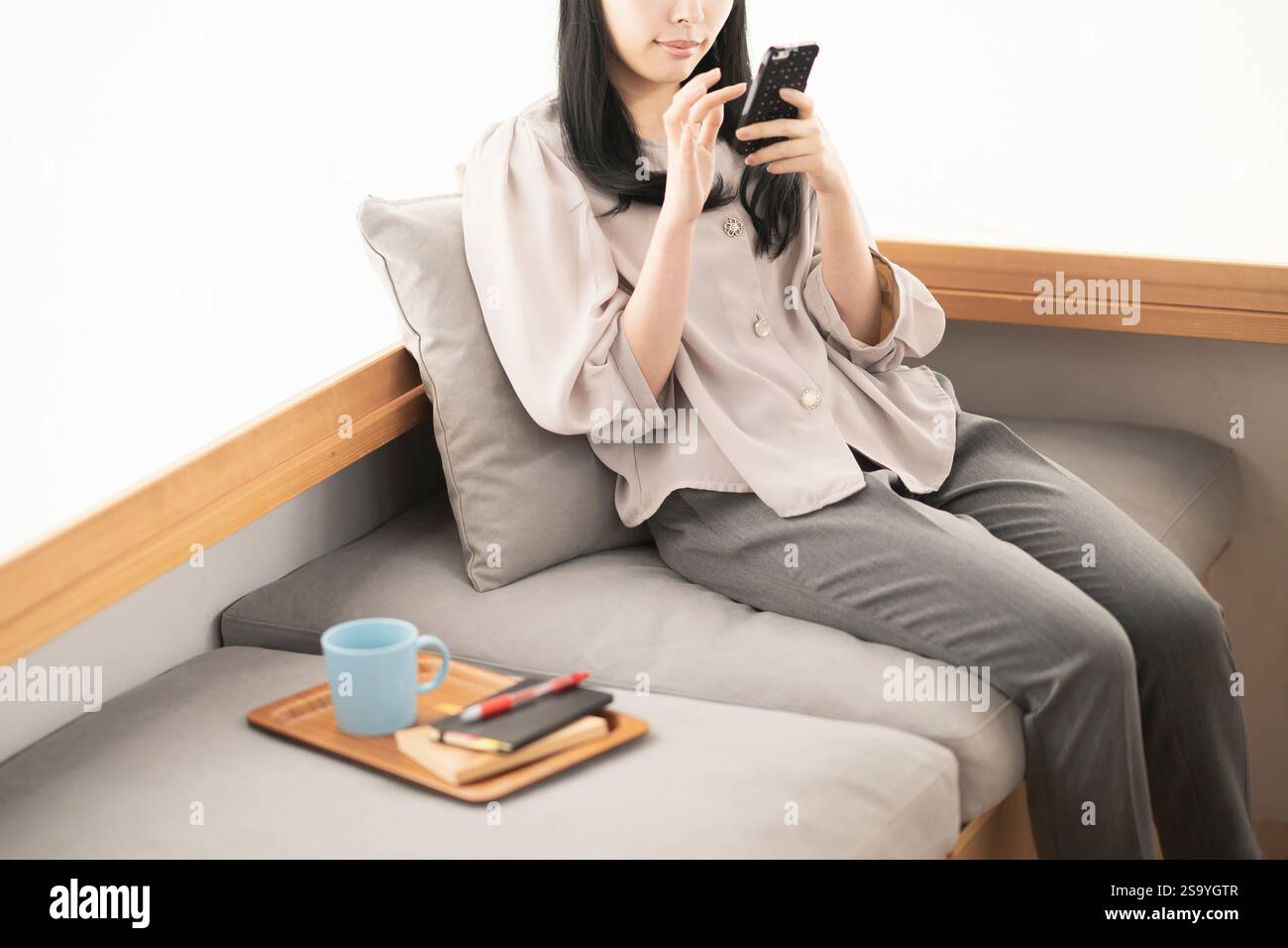 Woman operating a smartphone at home Stock Photo - Alamy