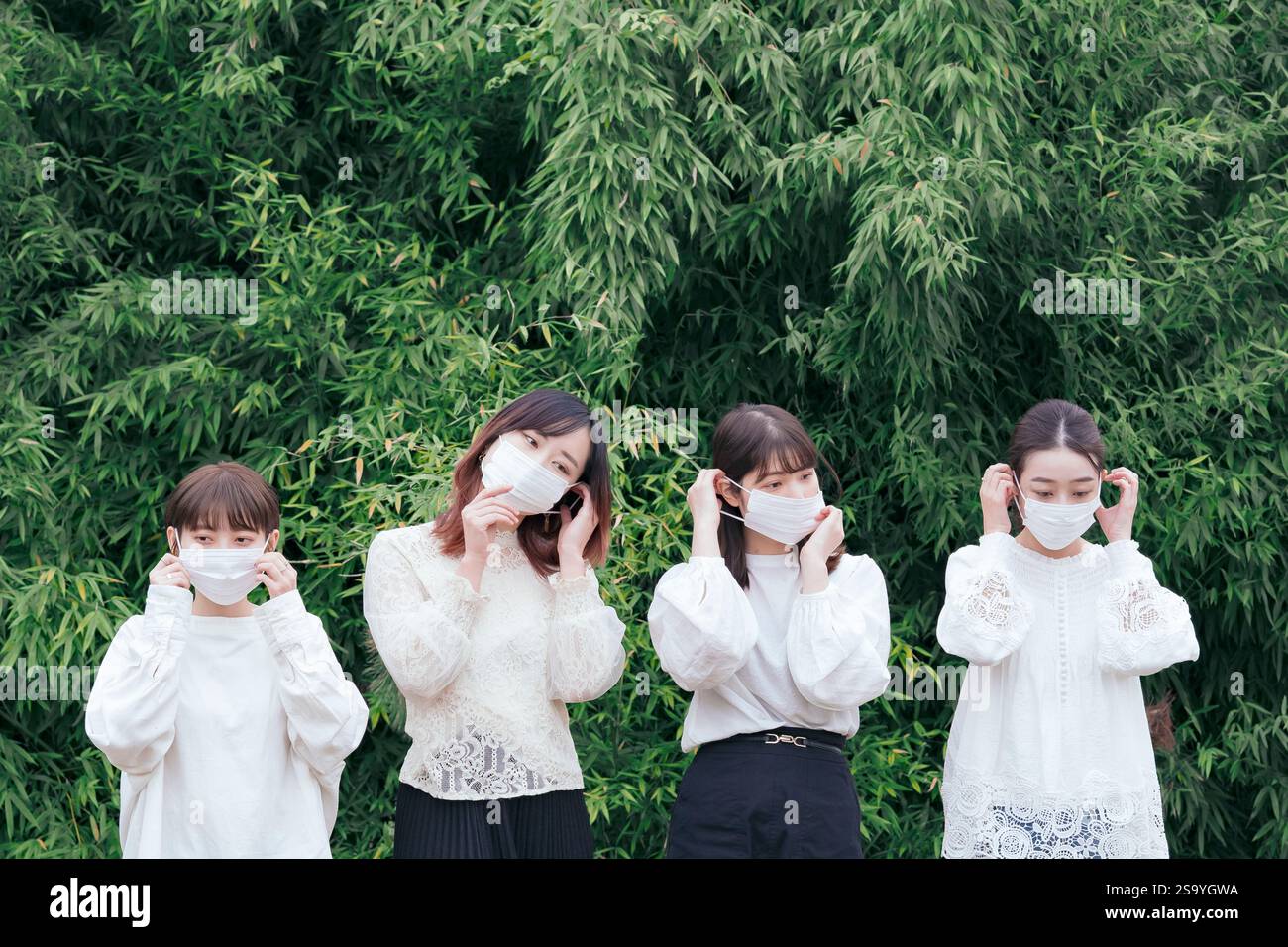 Four Japanese women wearing masks outdoors Stock Photo - Alamy