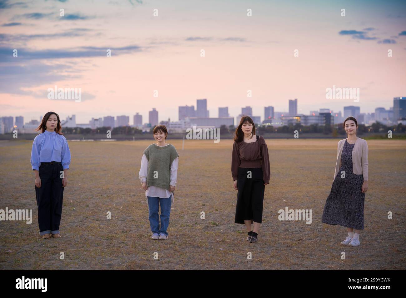 Four young women standing a short distance apart in the dusk Stock ...