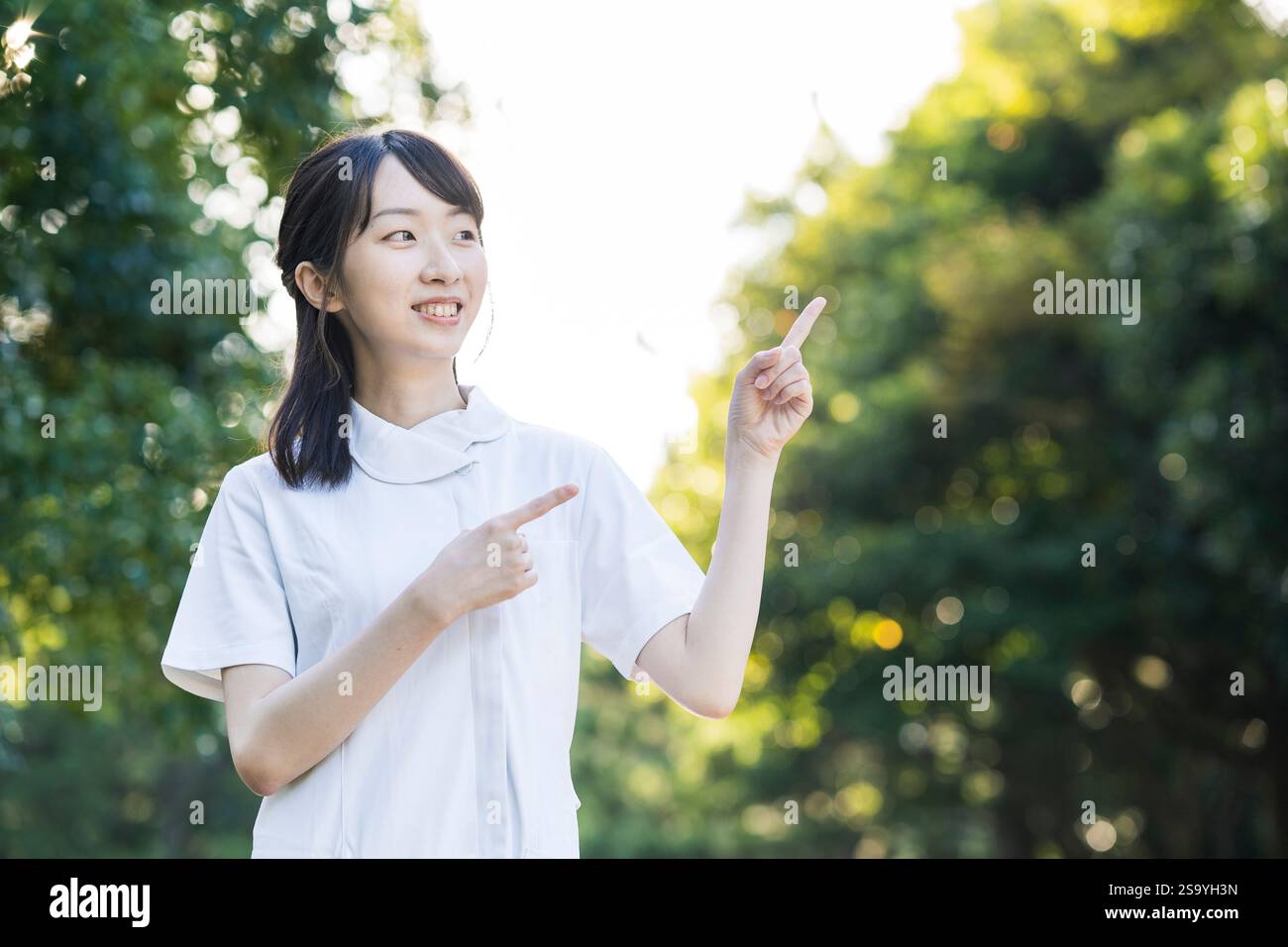 Woman in white coat striking a pointing pose Stock Photo - Alamy