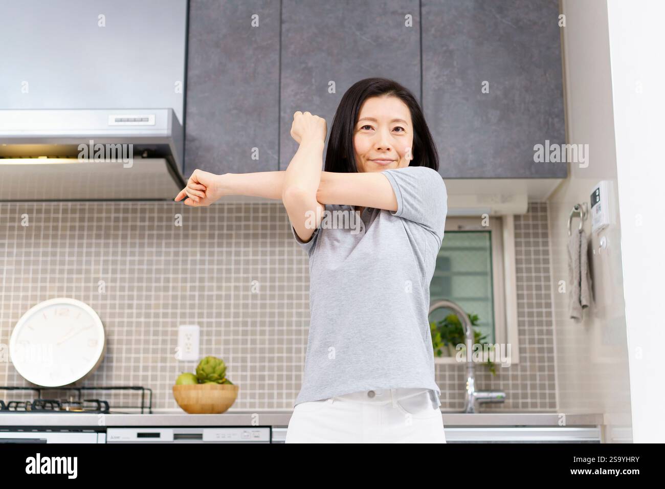 Middle-aged woman doing light exercise in her room at home Stock Photo ...