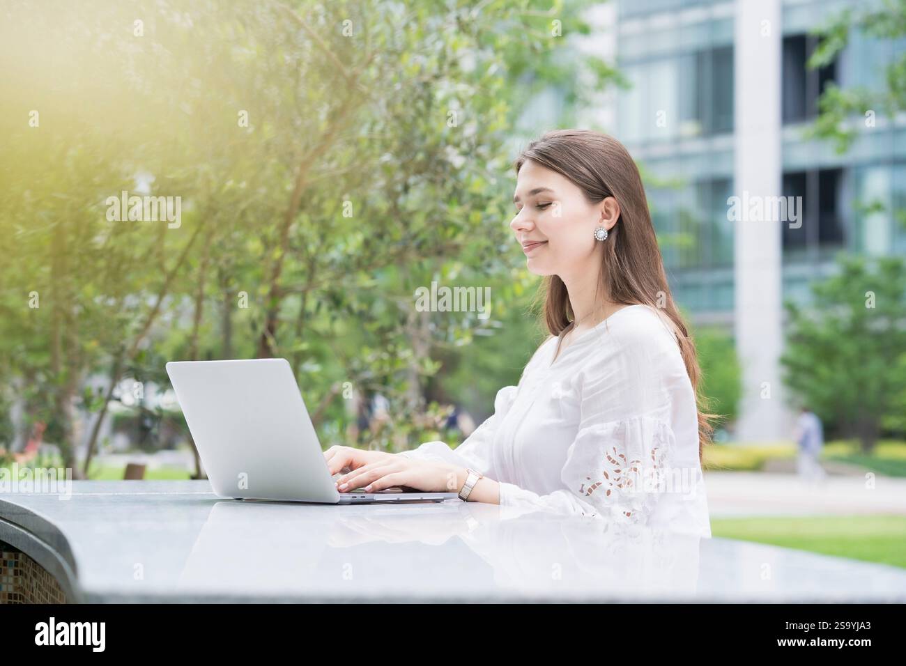 Woman operating a laptop outdoors Stock Photo - Alamy