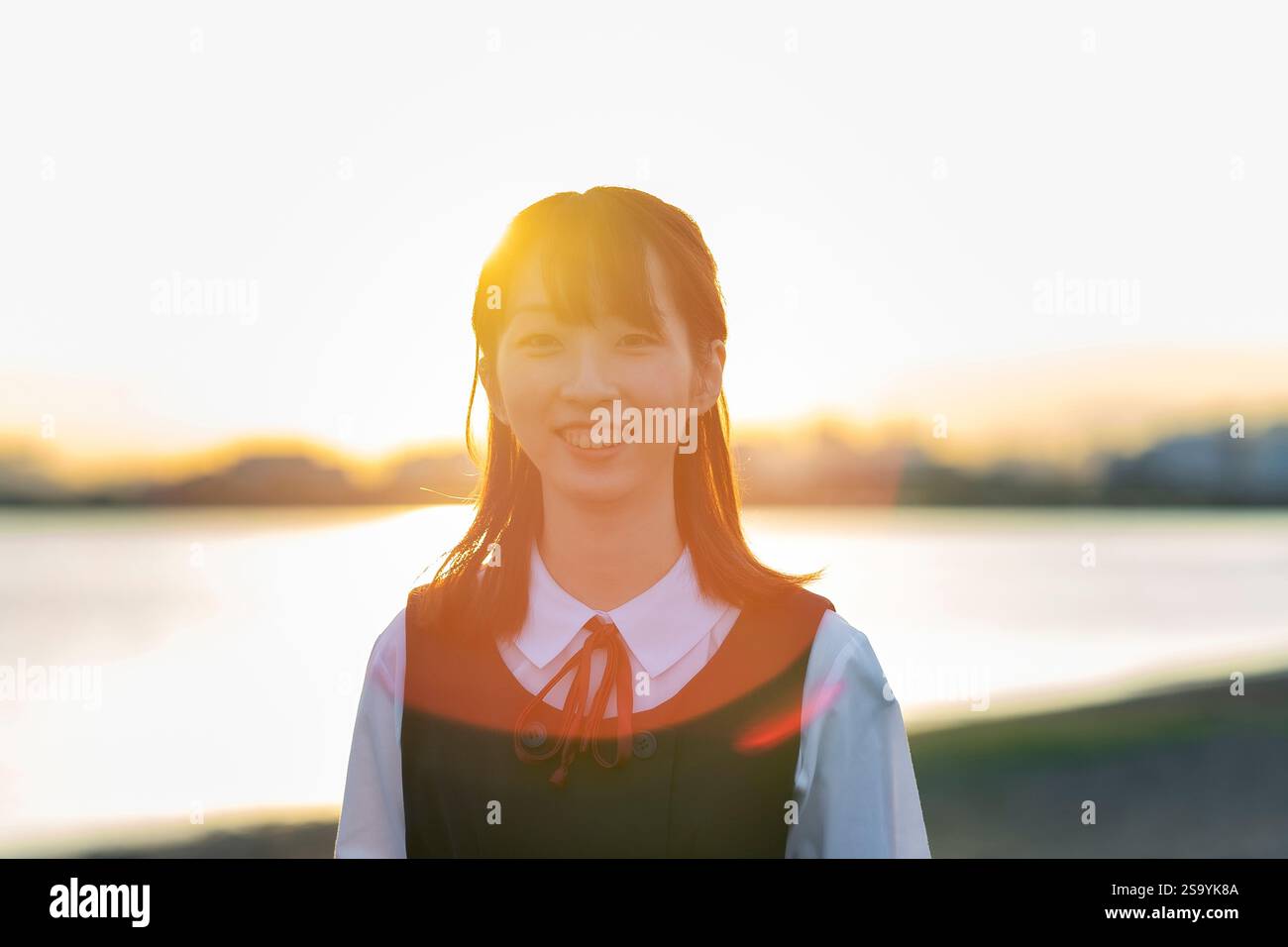 Asian female high school student surrounded by the setting sun Stock ...