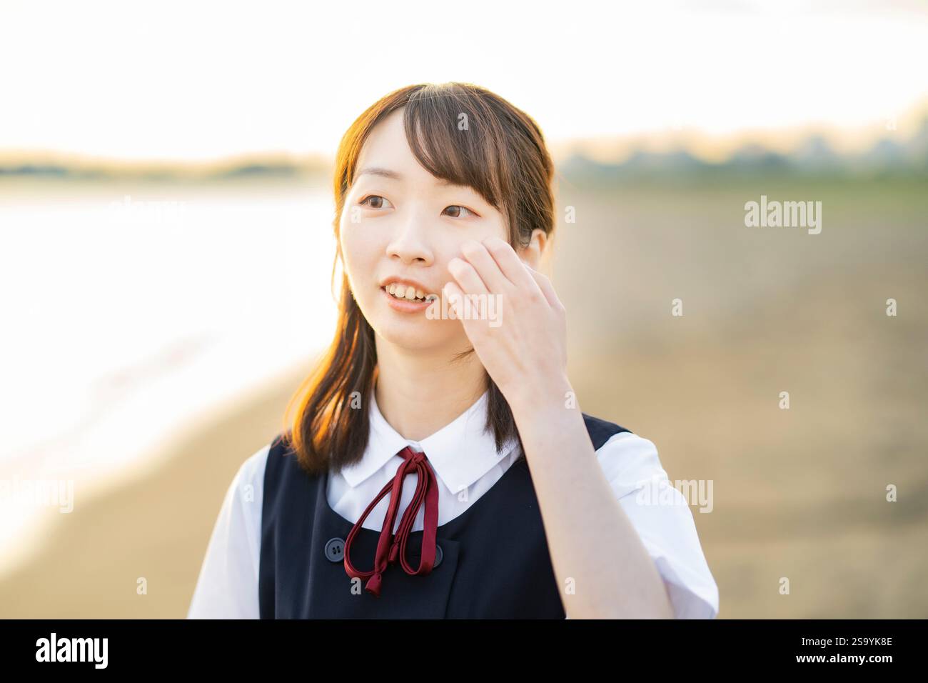 Asian female high school student surrounded by the setting sun Stock ...