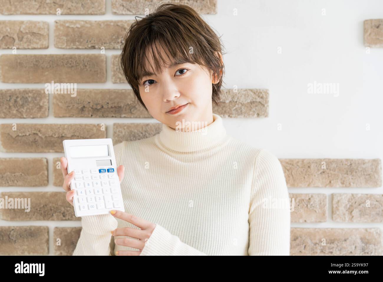 Young woman with a calculator and a stern expression on her face Stock ...