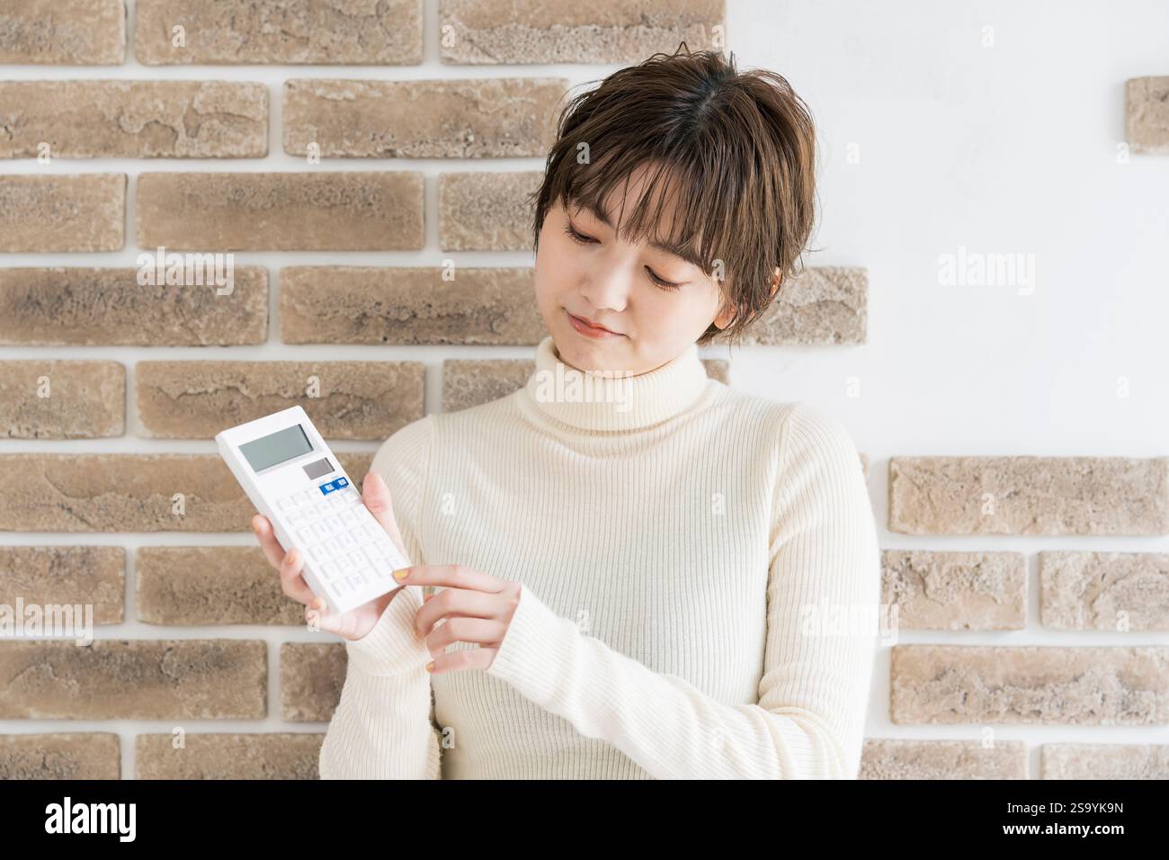 Young woman with a calculator and a stern expression on her face Stock ...