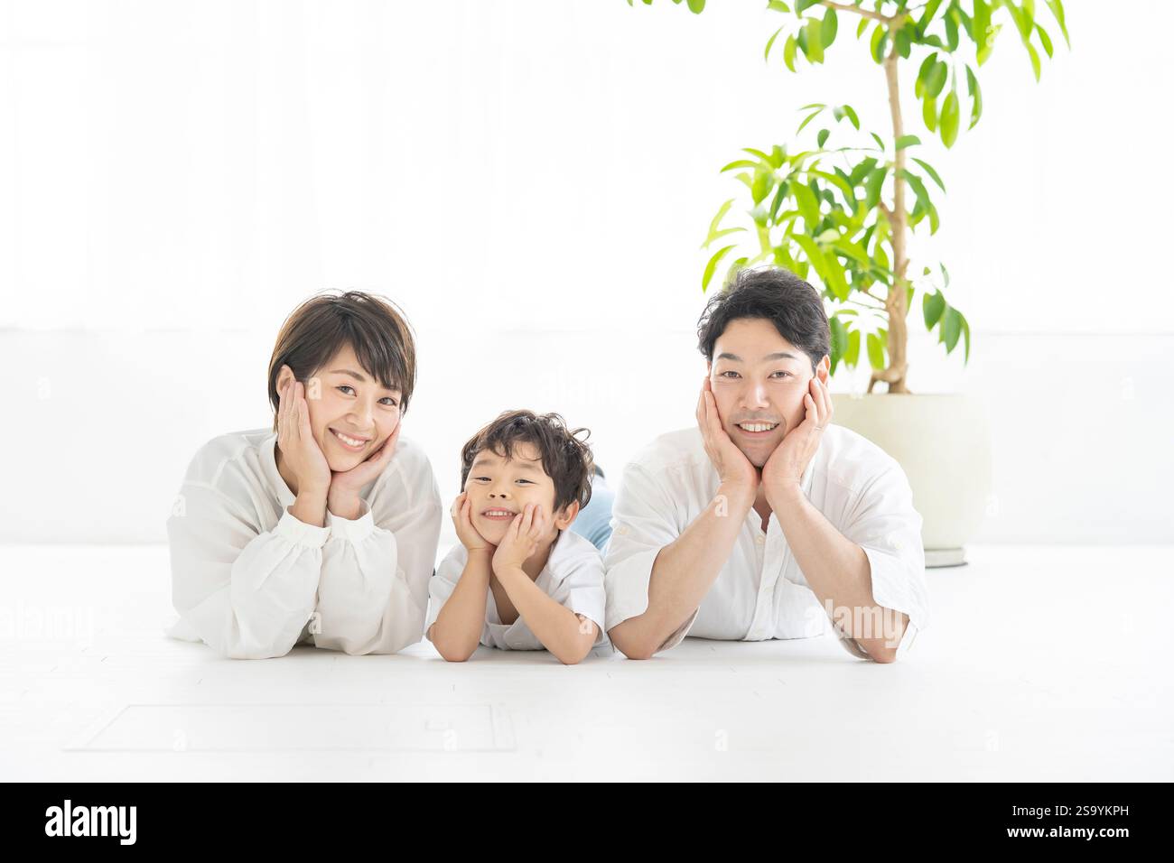 Three parents and children lying down in the same pose Stock Photo - Alamy