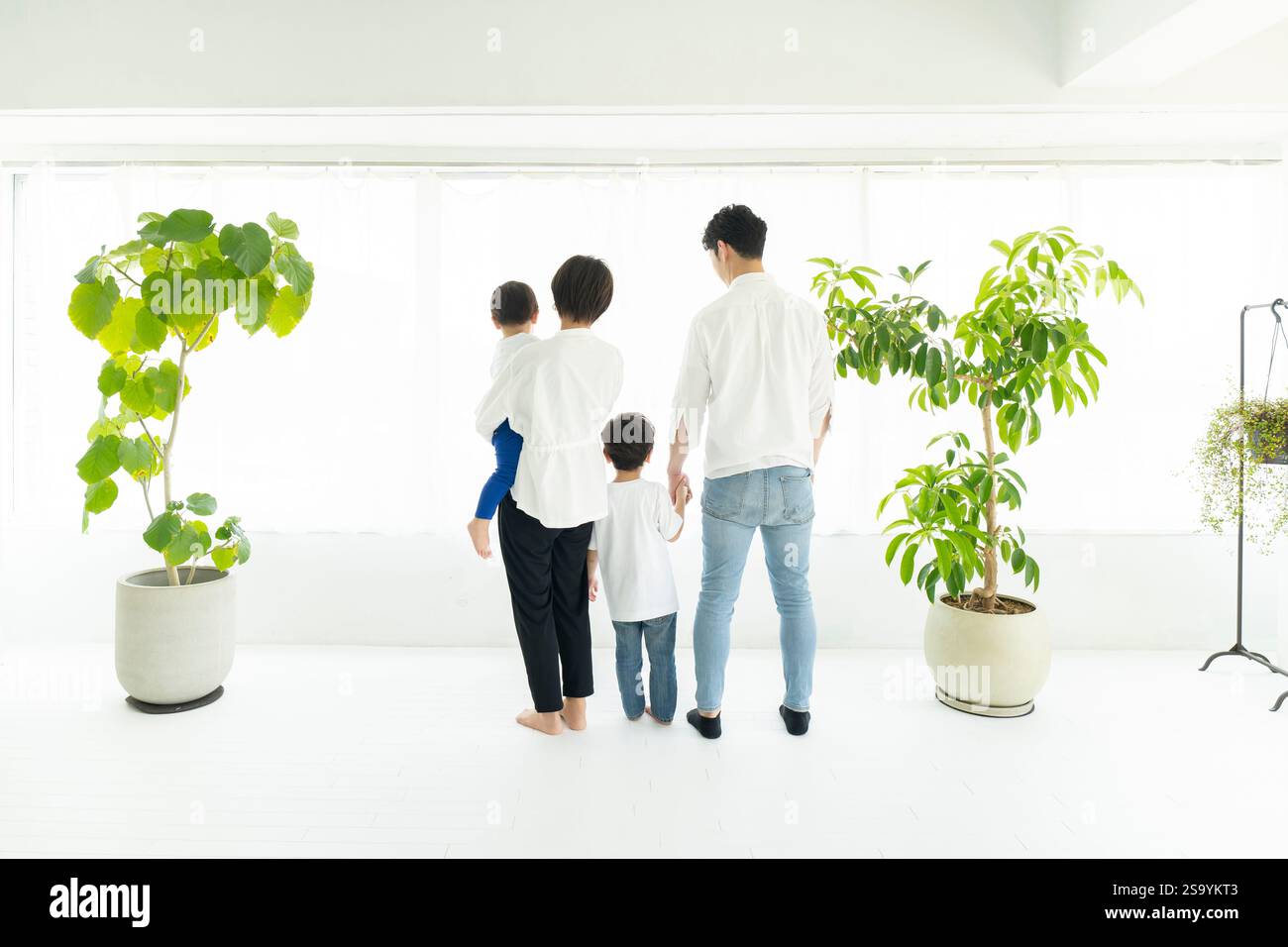 Backs of family members standing side by side by the window Stock Photo ...