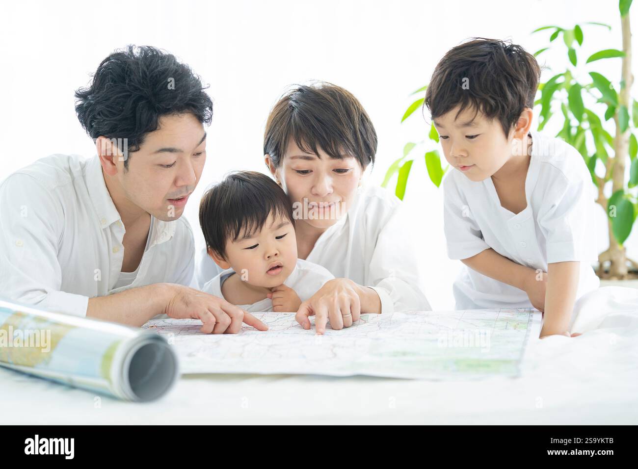 Parents and children having fun studying with a map / Parents and ...