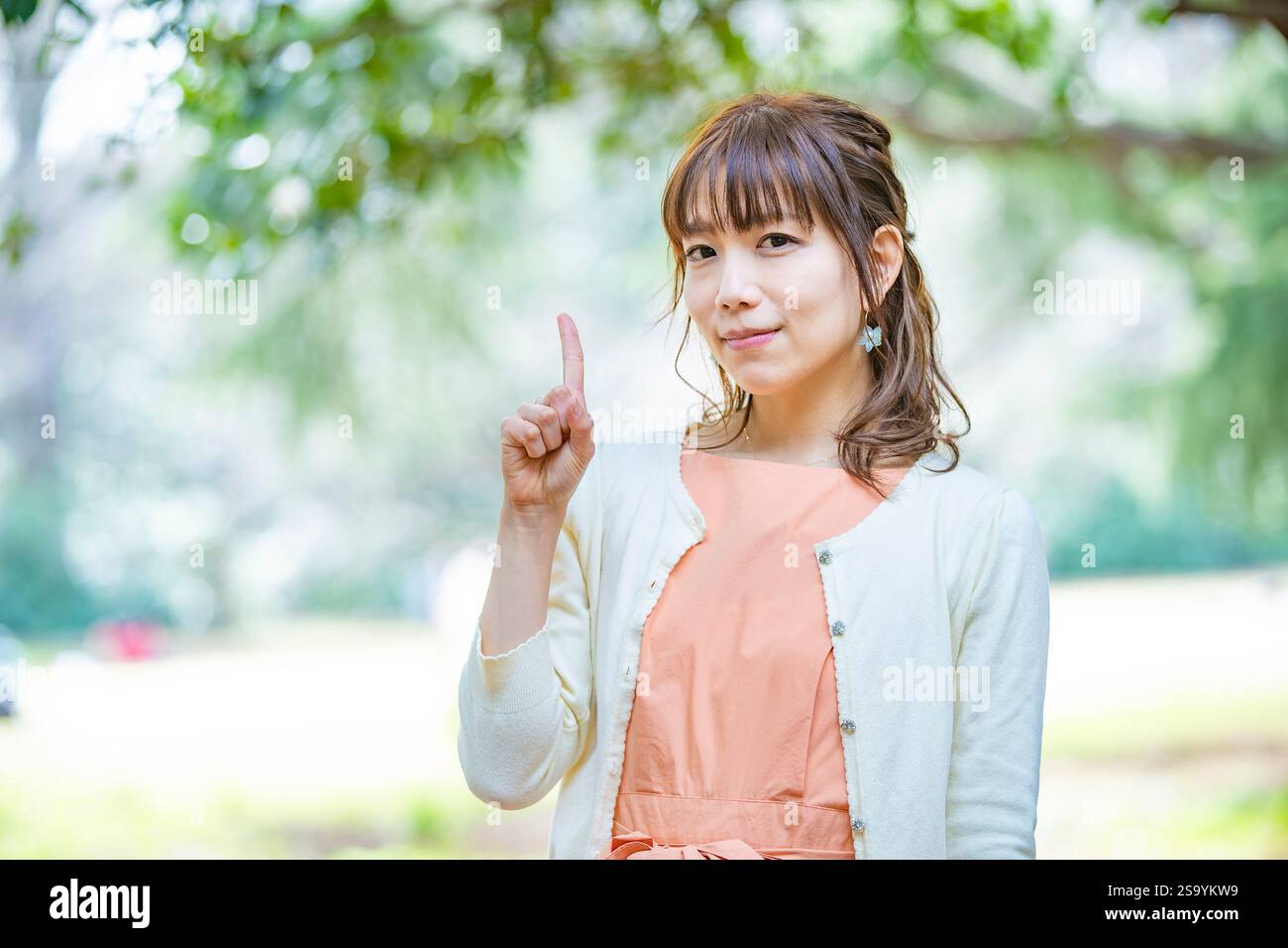 Woman striking a pose with index finger raised Stock Photo - Alamy