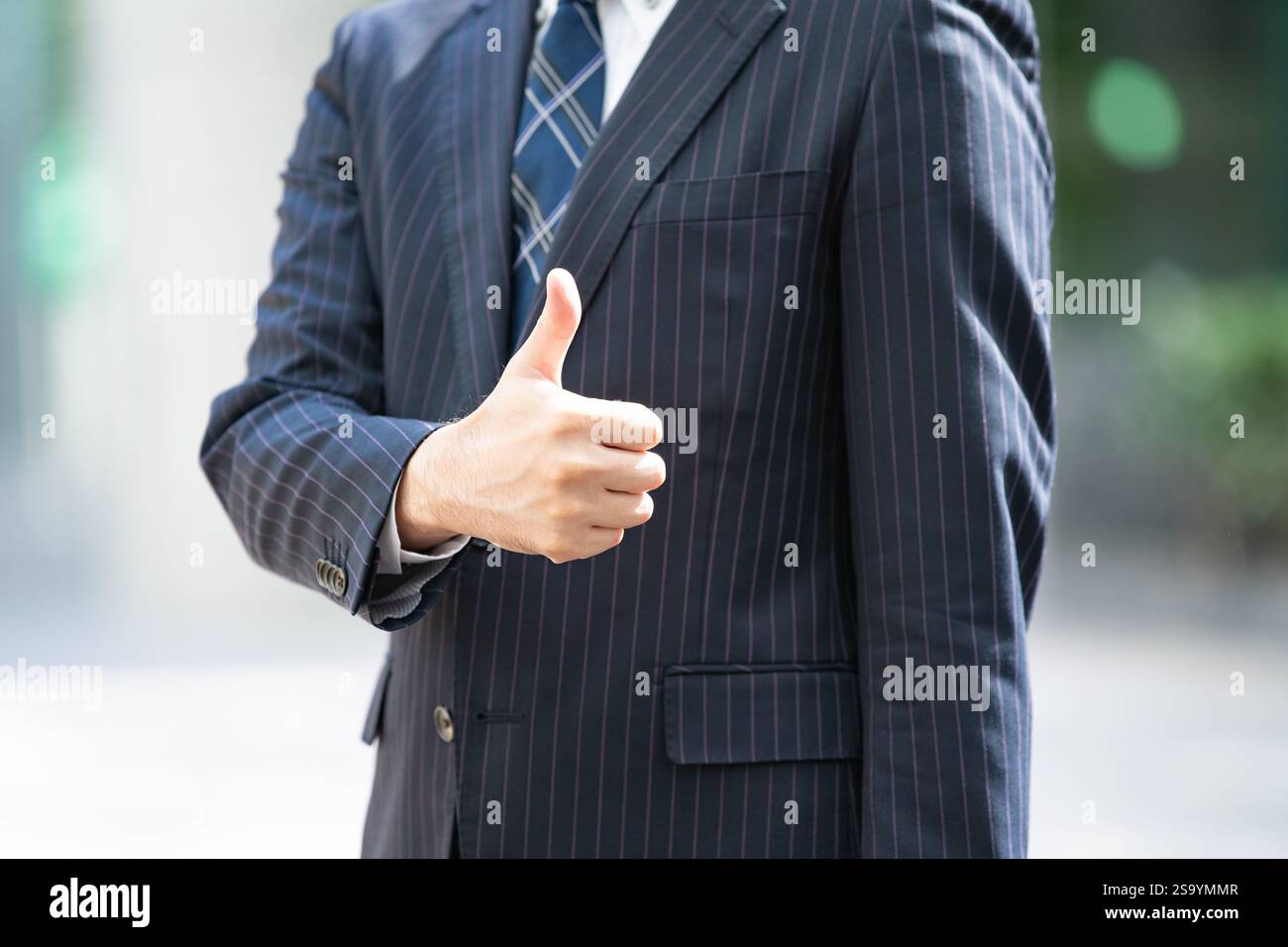 Businessman making the ‘thumbs up’ pose Stock Photo - Alamy