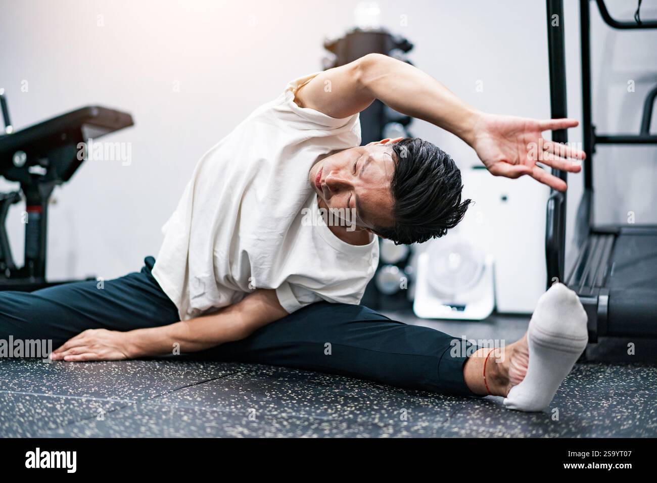 Man doing stretching exercises at the gym Stock Photo - Alamy