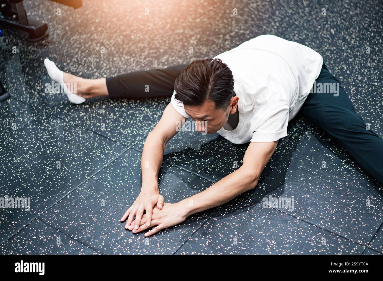 Man doing stretching exercises at the gym Stock Photo - Alamy