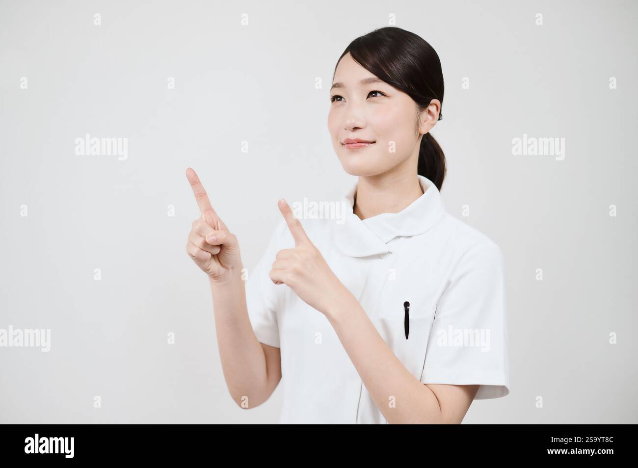 Woman in white coat striking a pointing pose Stock Photo - Alamy