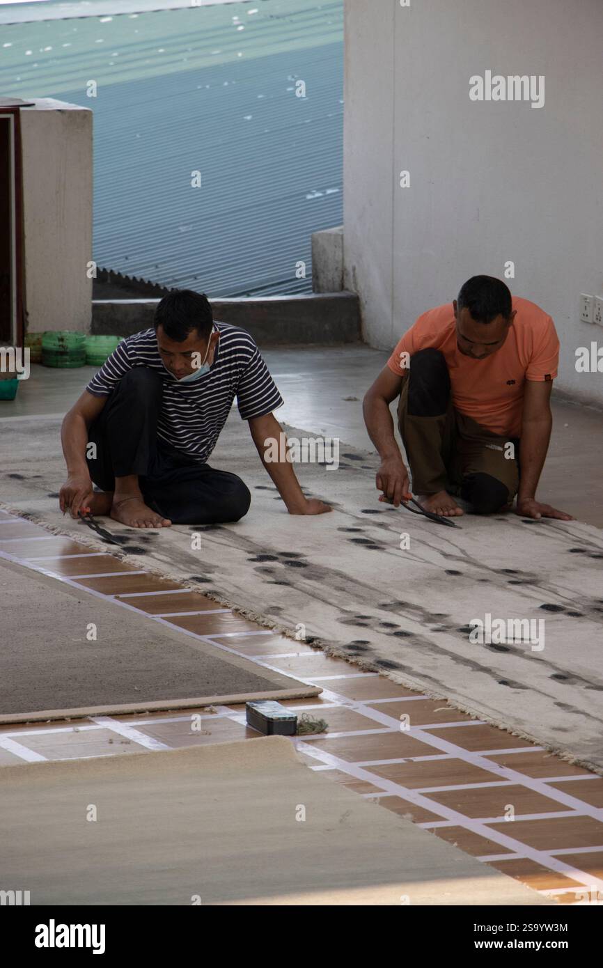 Carpet Factory workers giving a finishing touch to the carpets. Bouddha ...