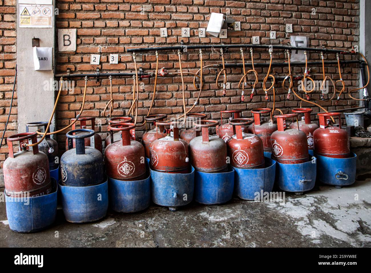 A series of cooking gas cylinders is arranged to provide fuel for the ...