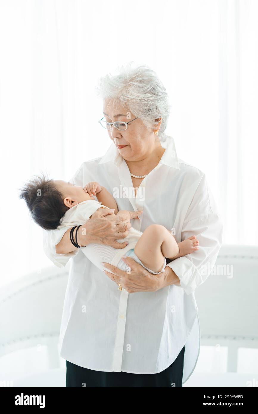 Senior woman carrying her baby Stock Photo - Alamy