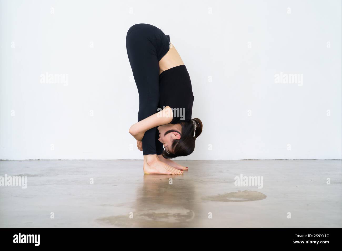 Woman doing forward bending exercise Stock Photo - Alamy