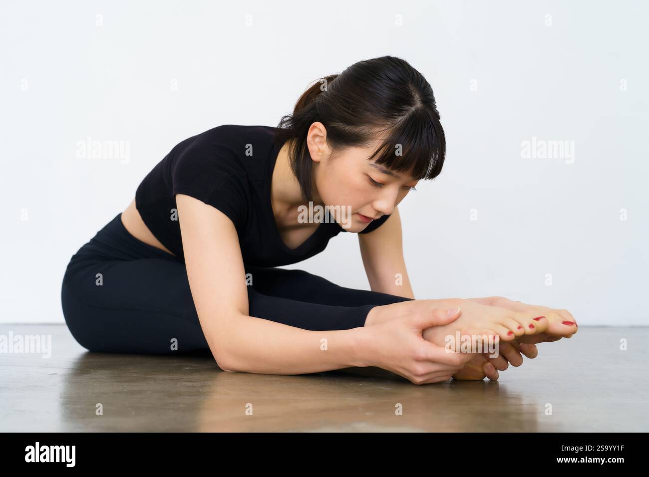 Woman doing forward bending exercise Stock Photo - Alamy