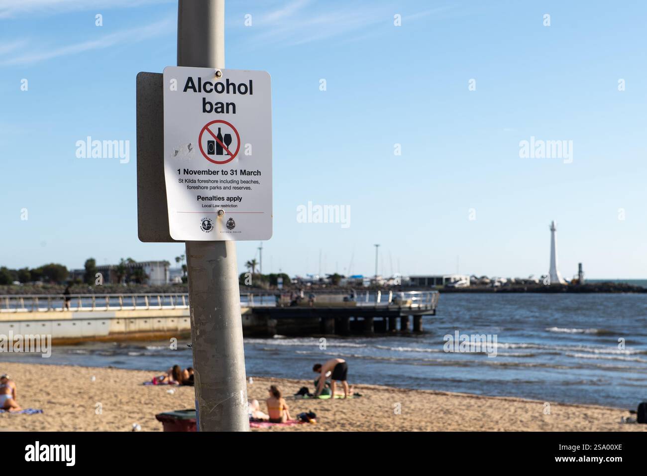 An alcohol ban sign mounted on a post on the promenade of St Kilda ...