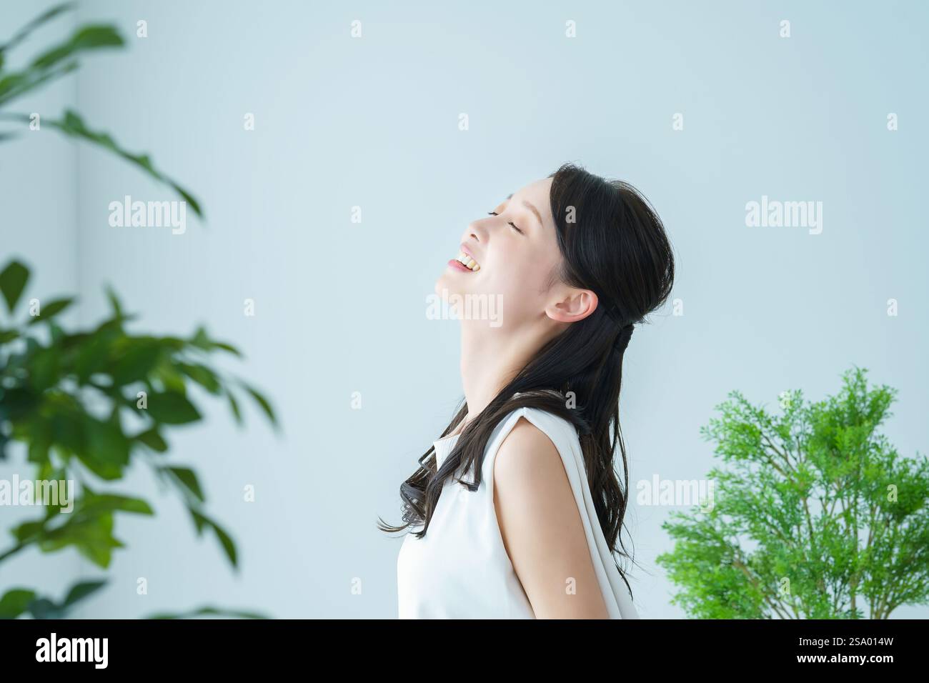Woman taking a deep breath in the light at the window Stock Photo - Alamy