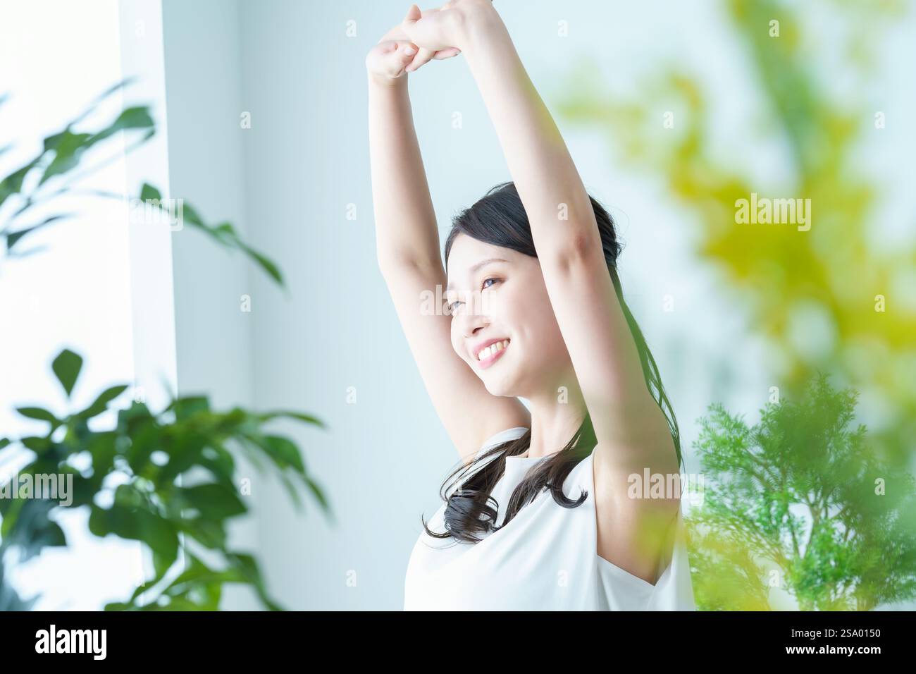 Woman taking a deep breath in the light at the window Stock Photo - Alamy