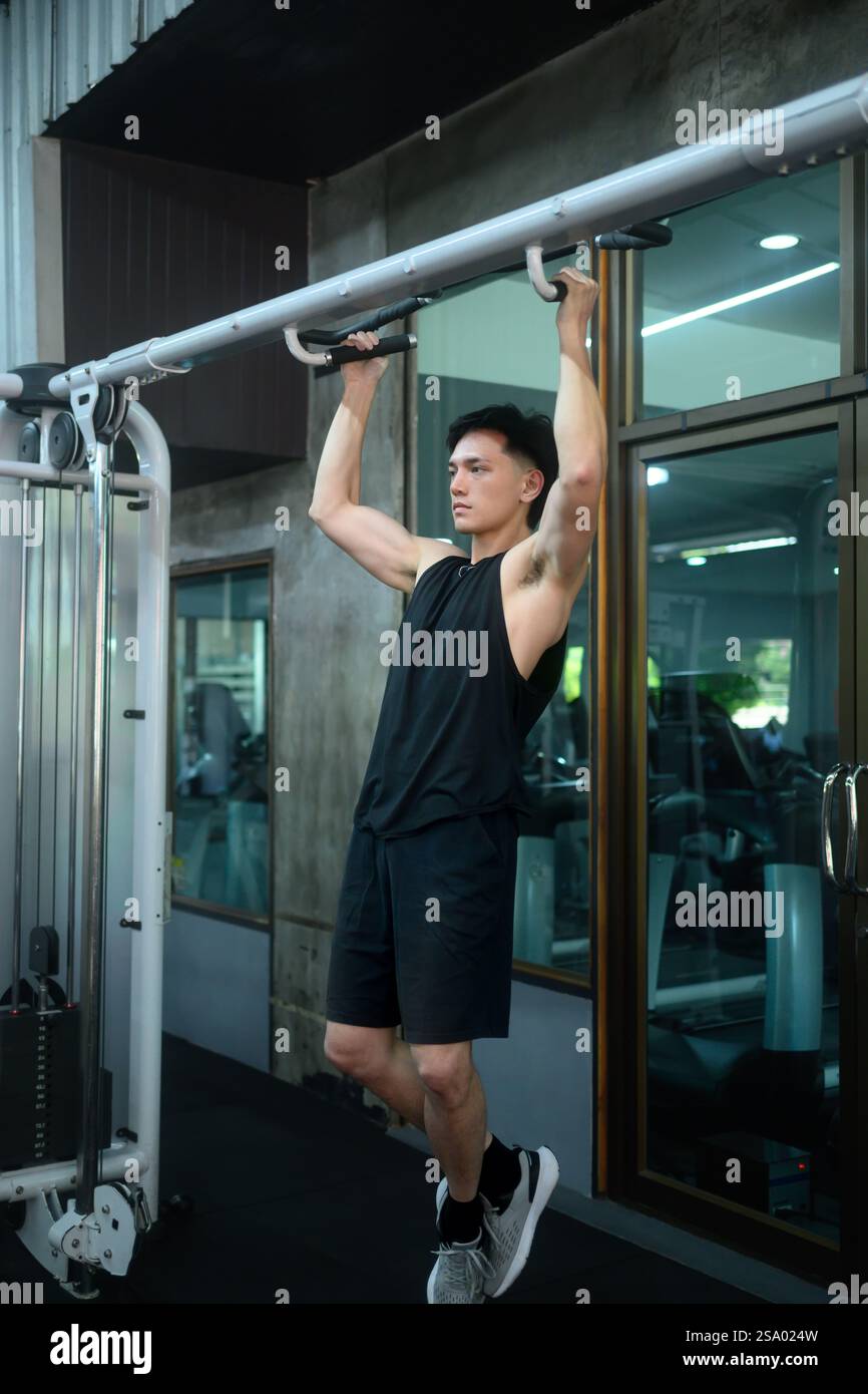 Athlete man doing pull ups on a bar in a modern gym Stock Photo - Alamy